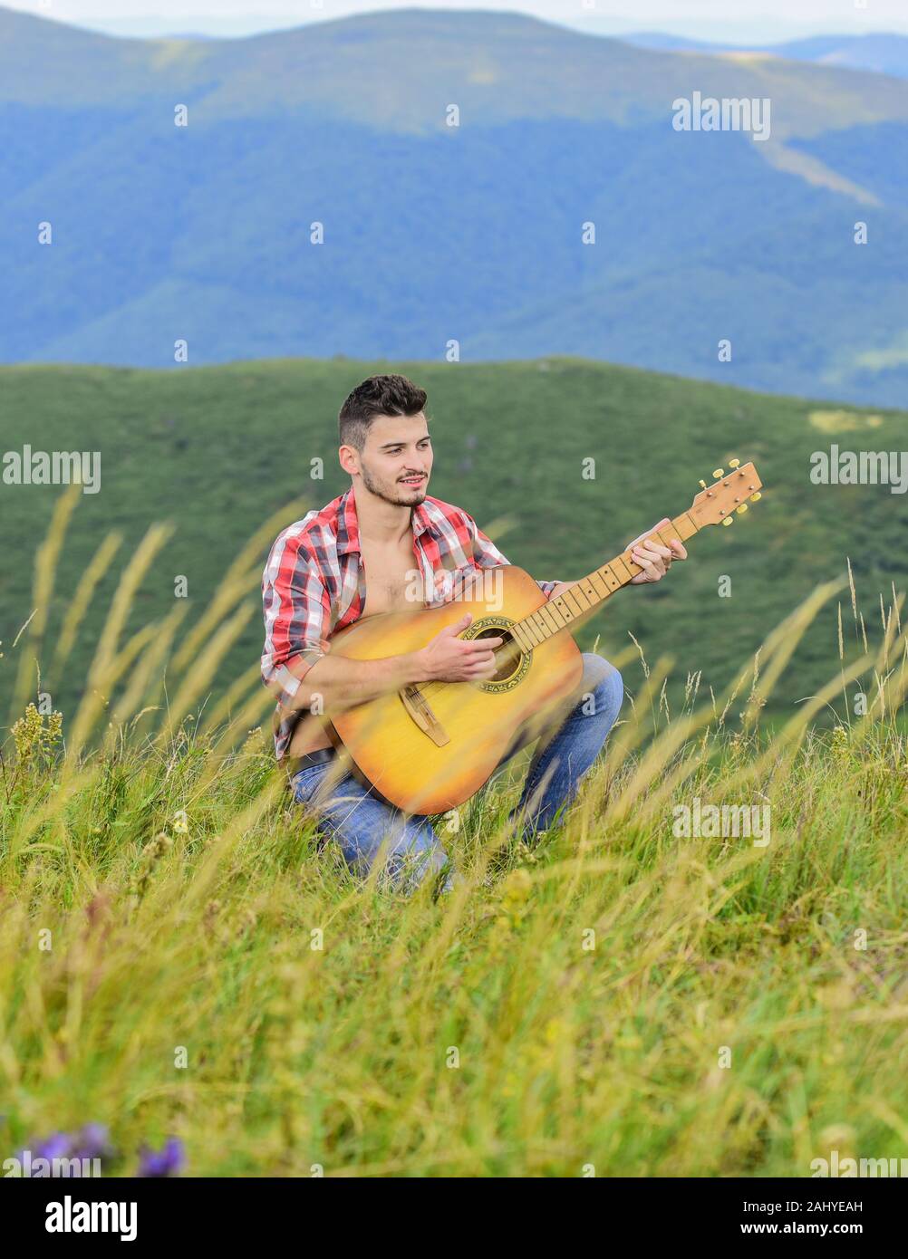 Acoustic music. Man with guitar on top of mountain. Summer music ...