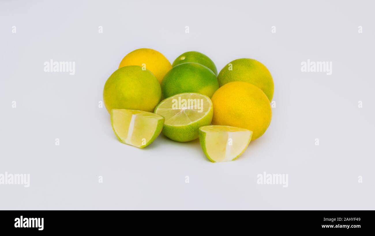 close up of six green and yellow lemon with slices isolated on white ...