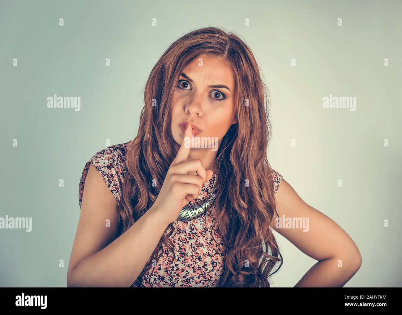 Woman gesturing silence, hush looking seriously and angrily at you ...