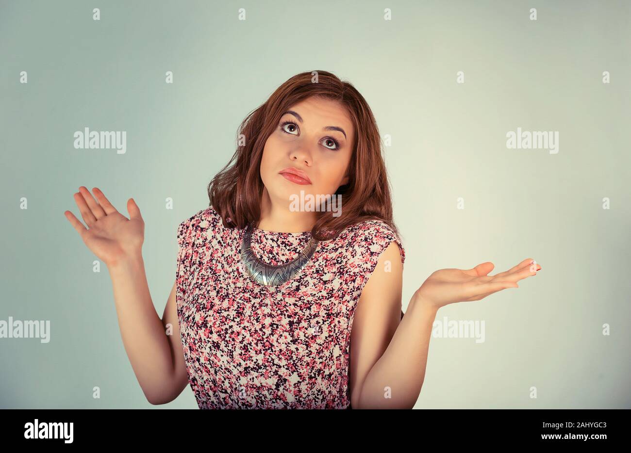 Woman puzzled shrugging shoulders in confusion, hands in air. Mixed ...