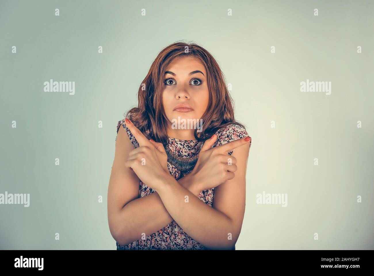 Portrait confused young woman pointing in two different directions not ...