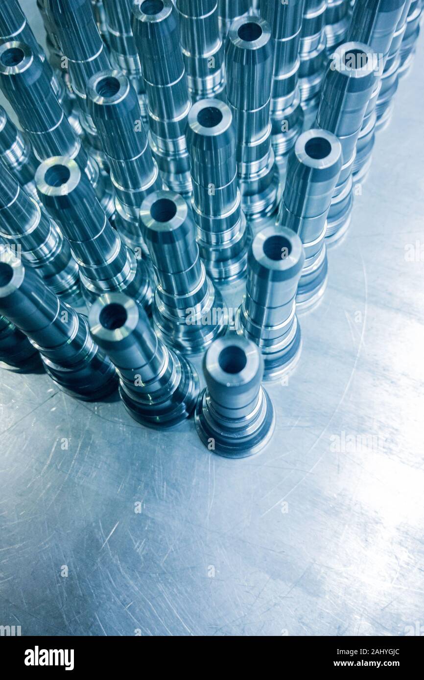 Shiny blue steel parts background, long clean steel threaded rods after ...