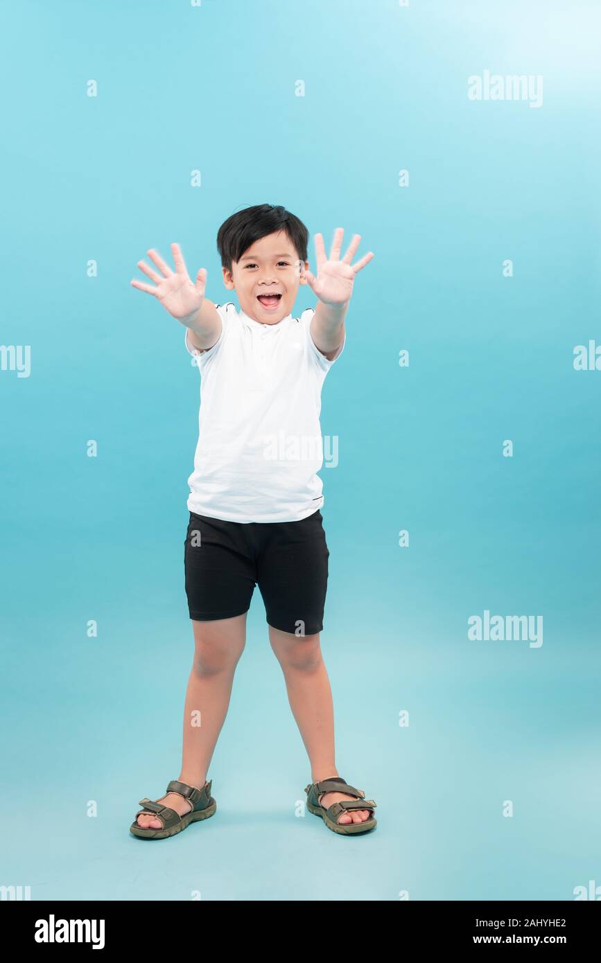 Happy little boy smiling and standing isolated on the white background ...
