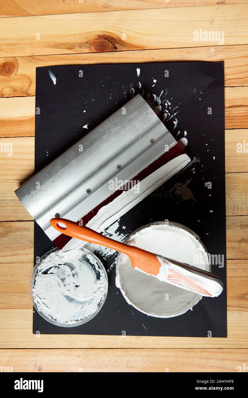 Tools for print on fabric. Scrapers and white paint Stock Photo - Alamy