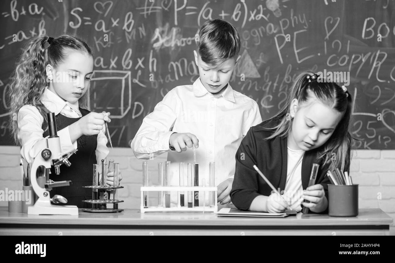 students doing biology experiments with microscope. Little children at ...