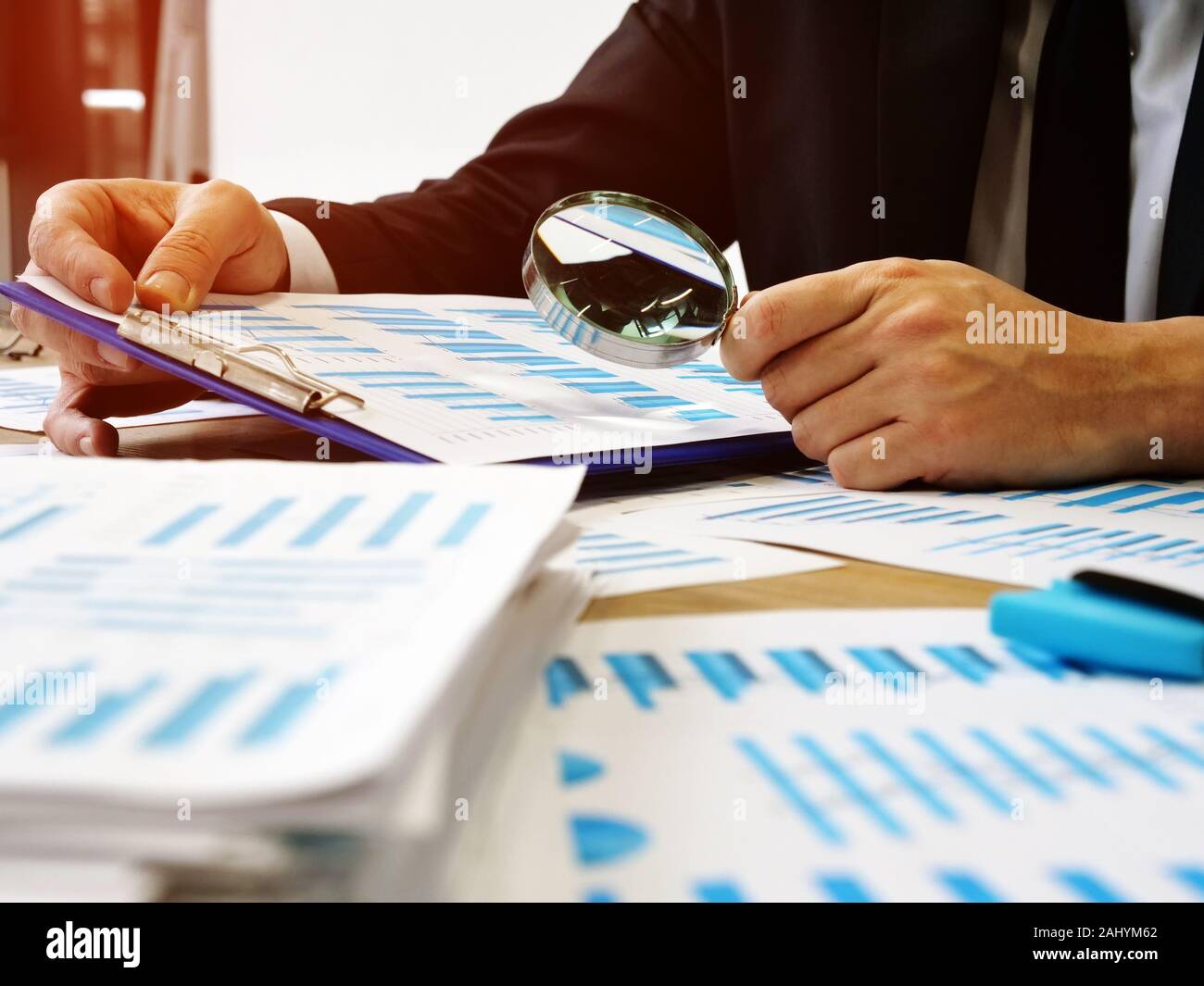 The auditor makes audit and verifies the report using a magnifying ...