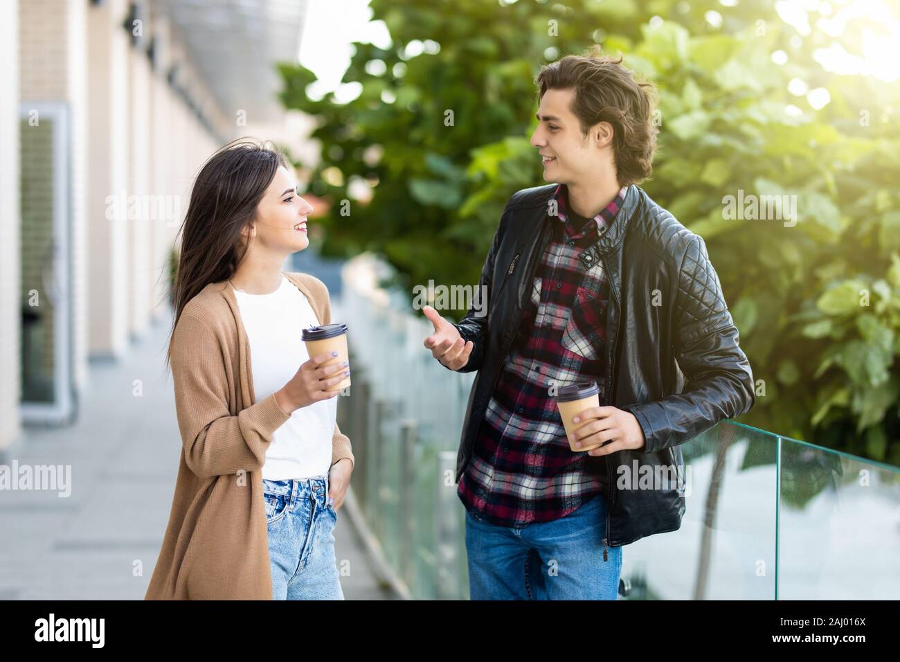 Pretty couple drinking coffee on the street cafe having fun together ...