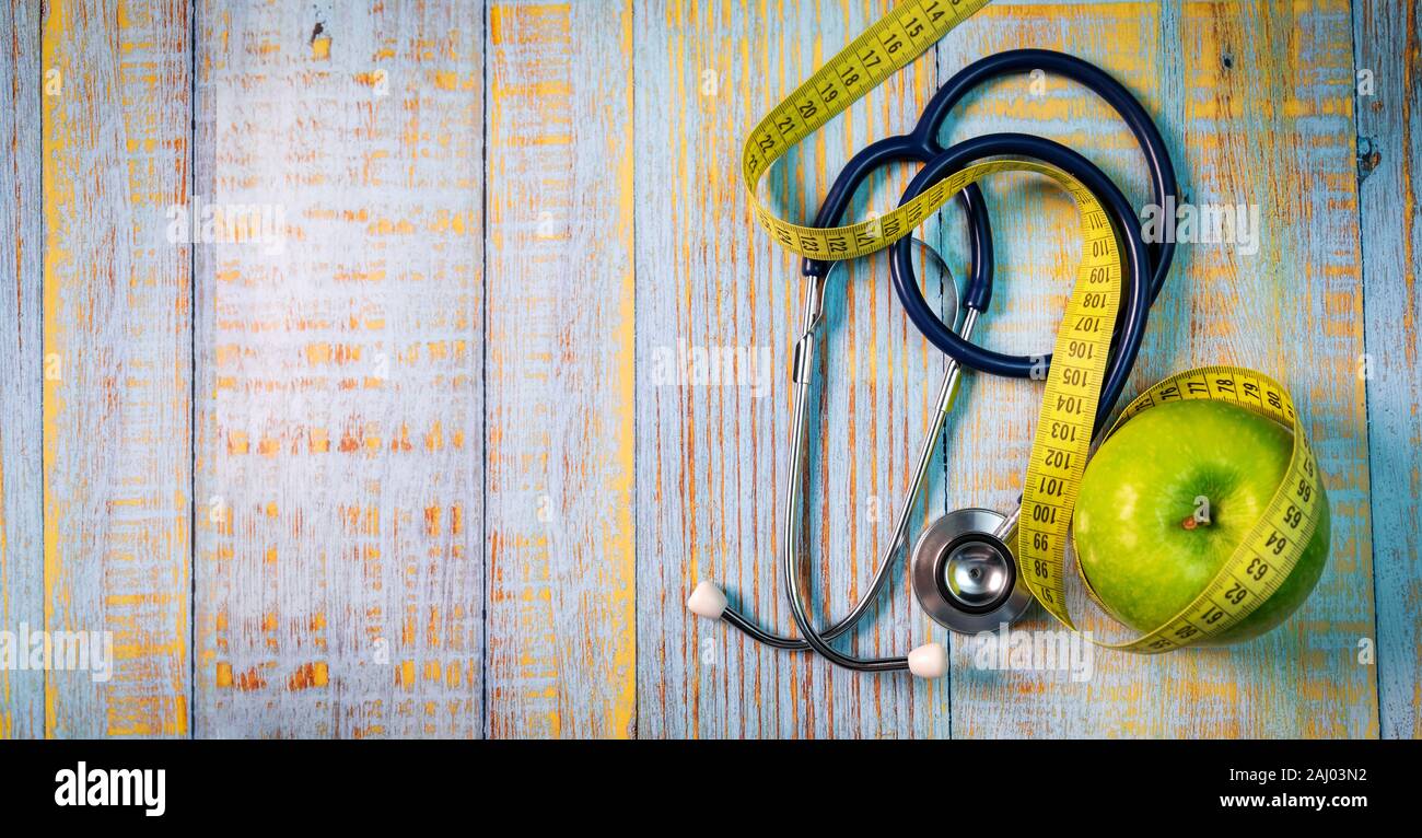 dietitian nutritionist concept - apple with measurement tape and ...