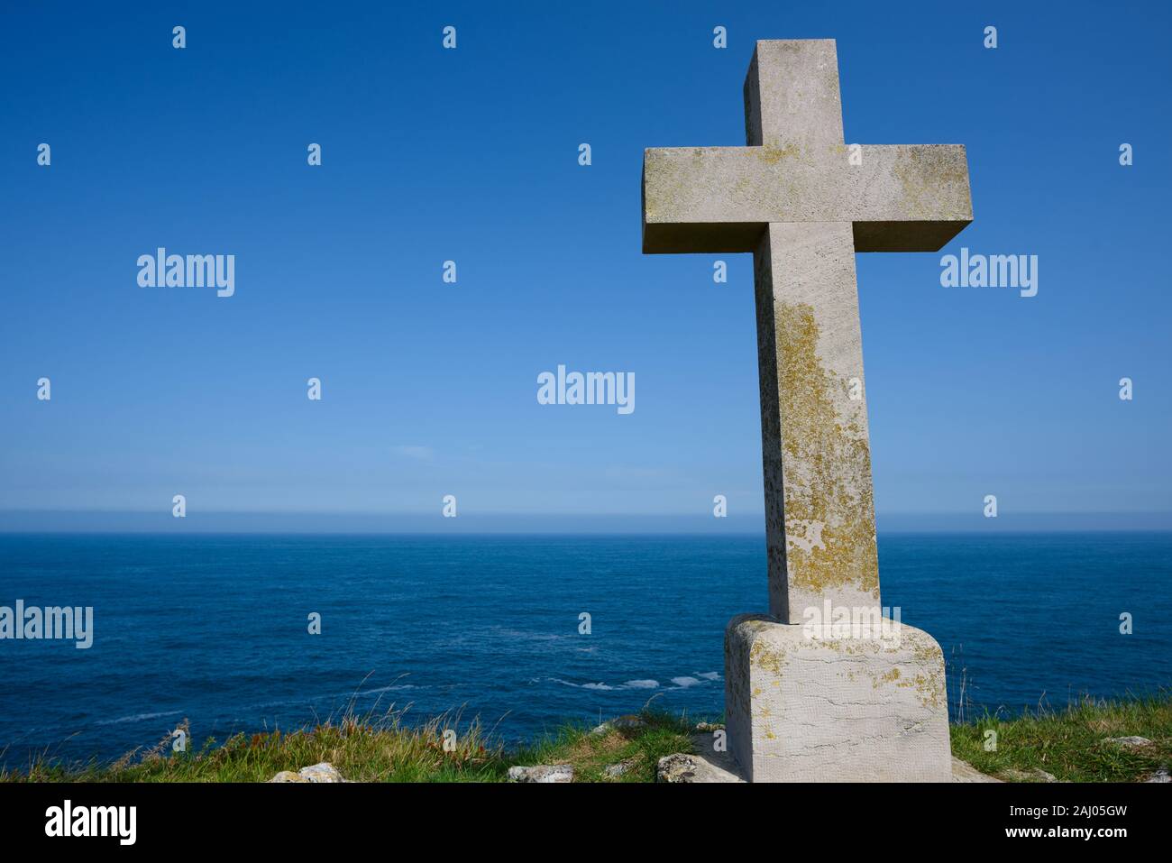 Cross on rock at ocean coast at clear day Stock Photo - Alamy