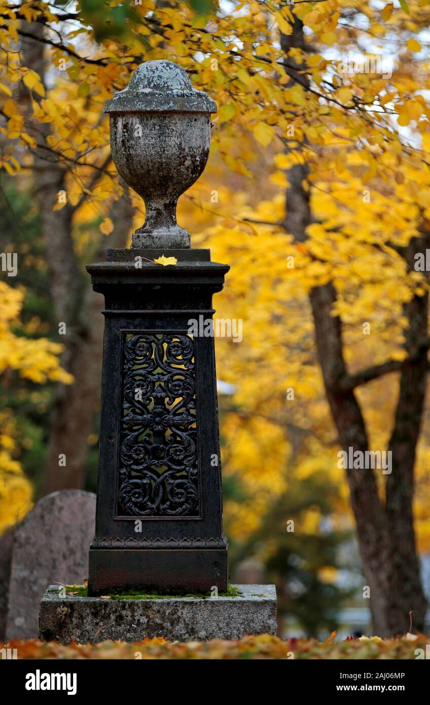 An old memorial on an ancient graveyard with beautiful yellow maple ...