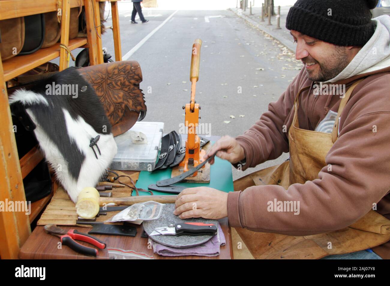 Working process of leather craftsman. Tanner or skinner sews leather or ...