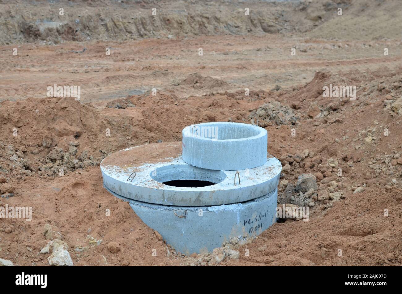 Installation of concrete sewer wells in the ground at the construction ...