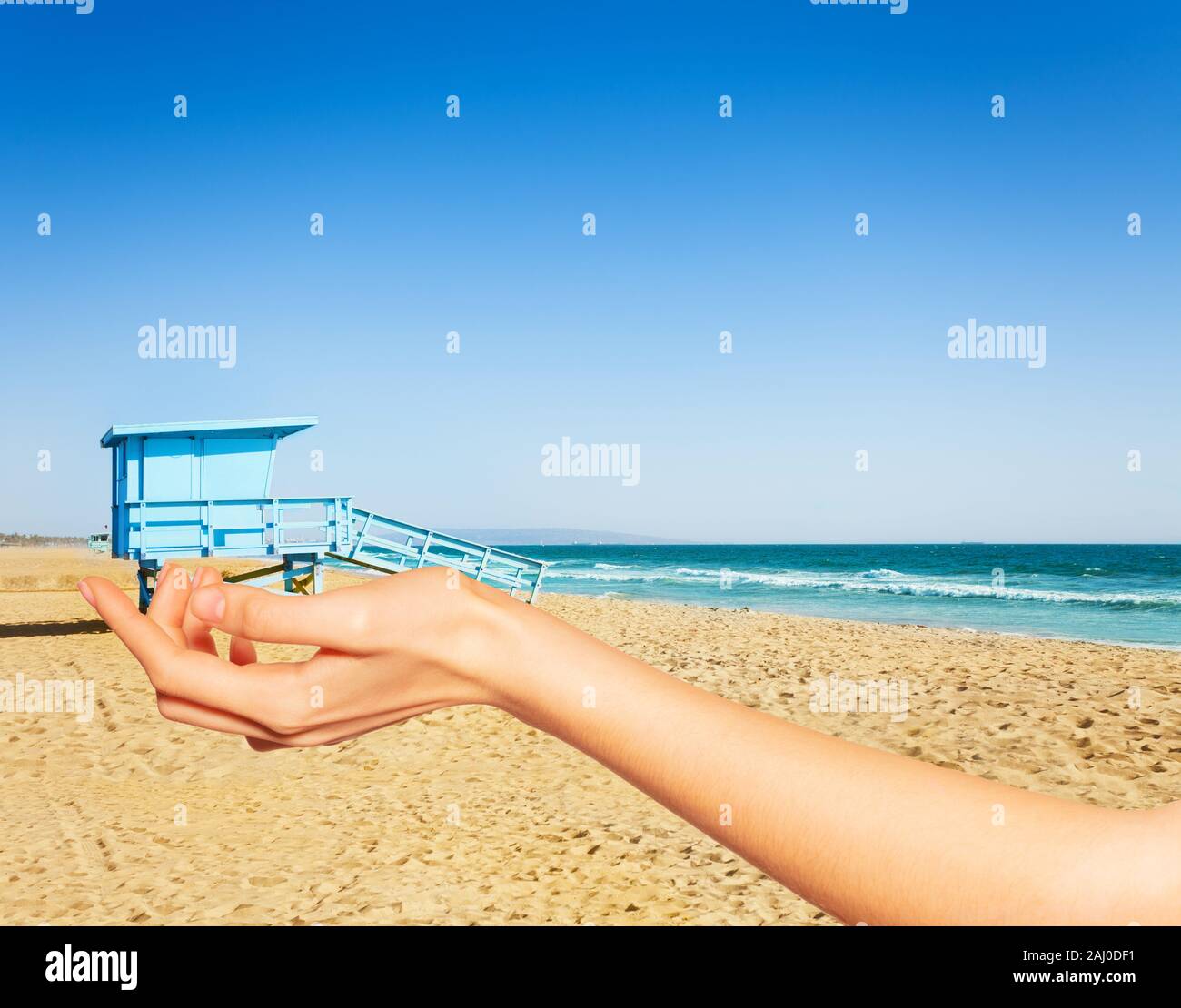 Hand hold between fingers lifeguard tower LA beach Stock Photo - Alamy