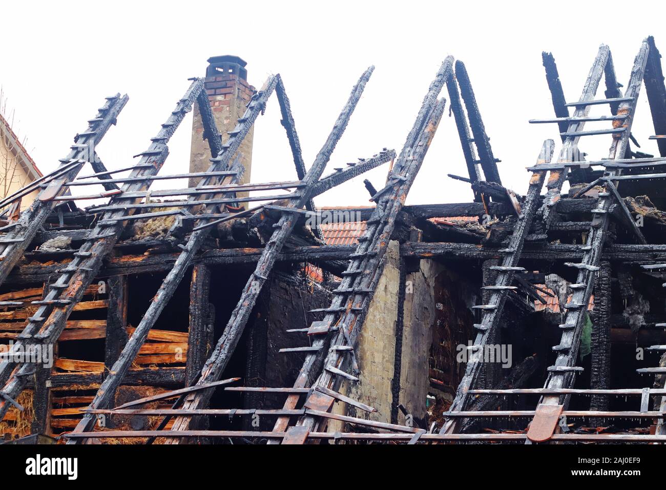 close-up of a charcoaled roof truss after a fire in a small old house ...