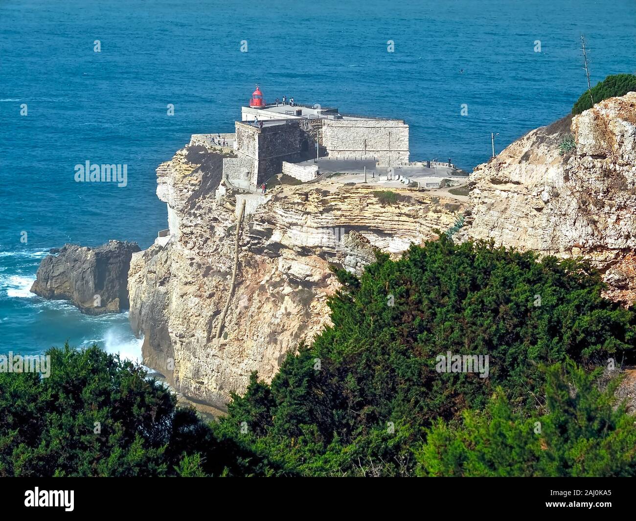 Famous lighthouse in Nazare in Portugal surrounded by Atlantic ocean ...