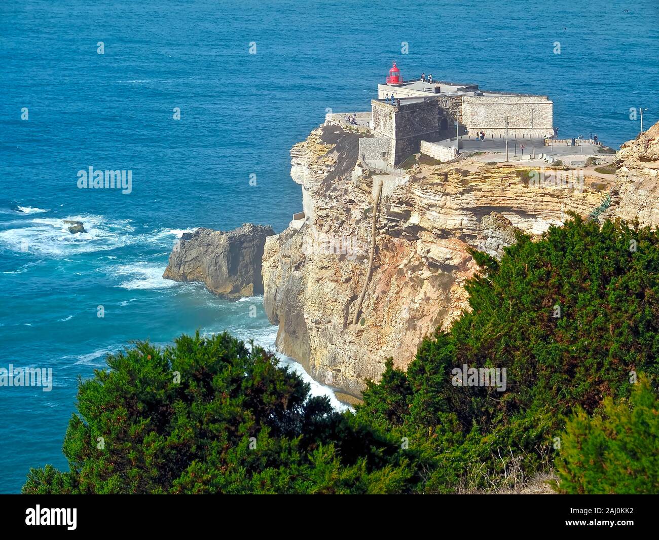 Famous lighthouse in Nazare in Portugal surrounded by Atlantic ocean ...