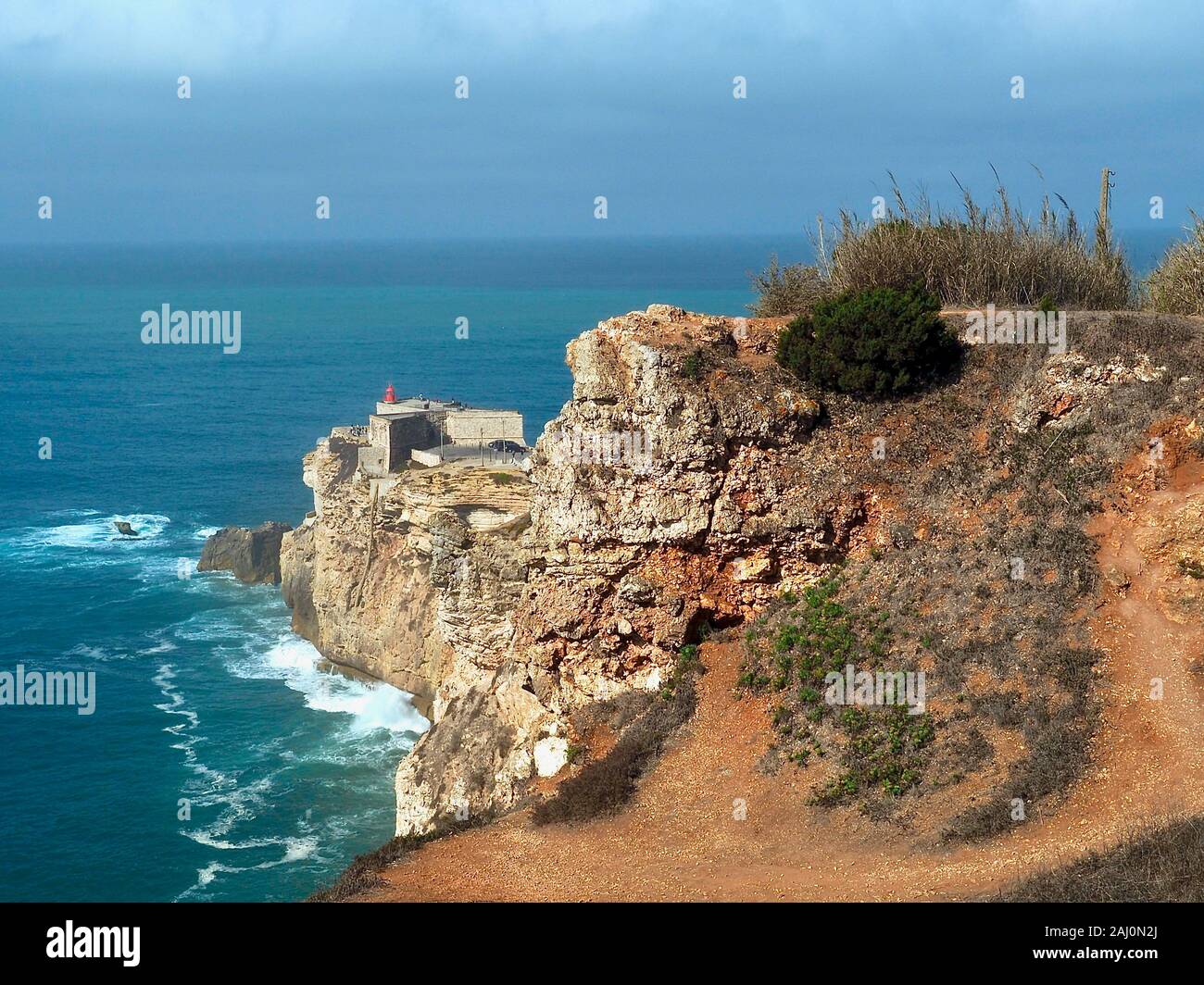 Famous lighthouse in Nazare in Portugal surrounded by Atlantic ocean ...