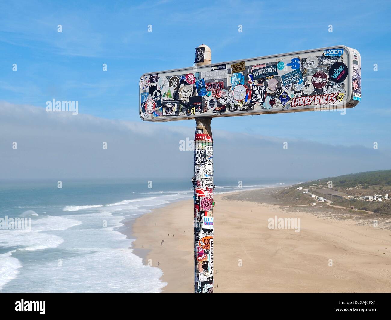 Street sign with stickers at North beach of Nazare seen from the ...