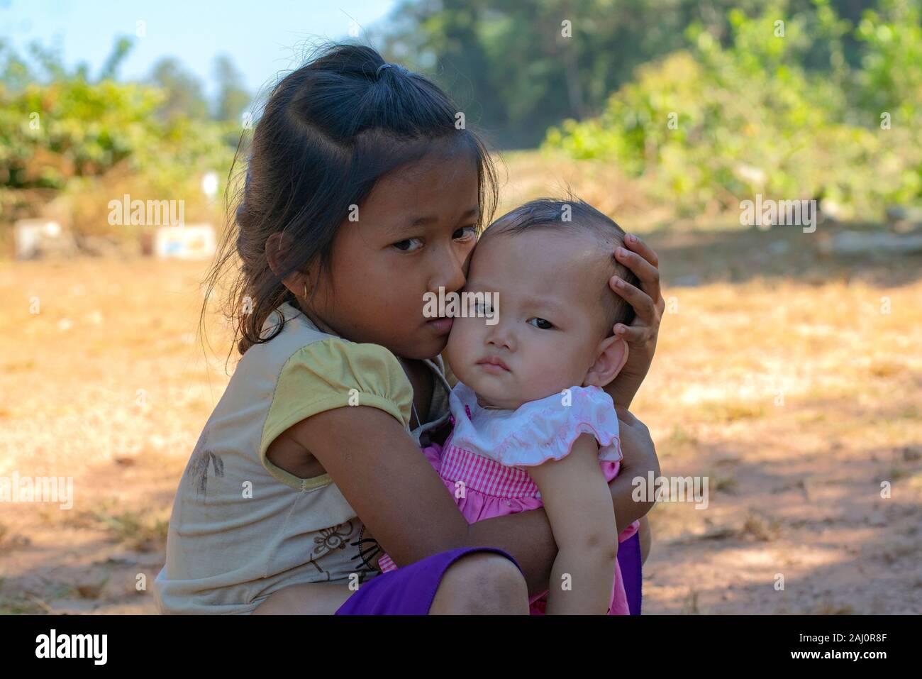 An Asian girl takes care of her little sister Stock Photo - Alamy