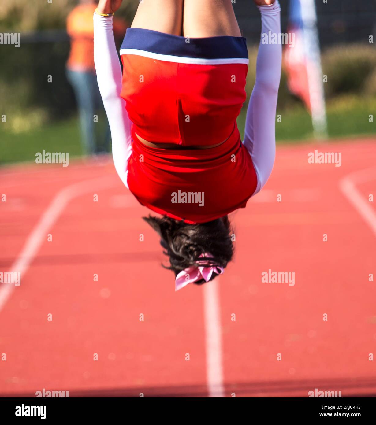 A high school cheerleader doing a flip during a time out of the ...