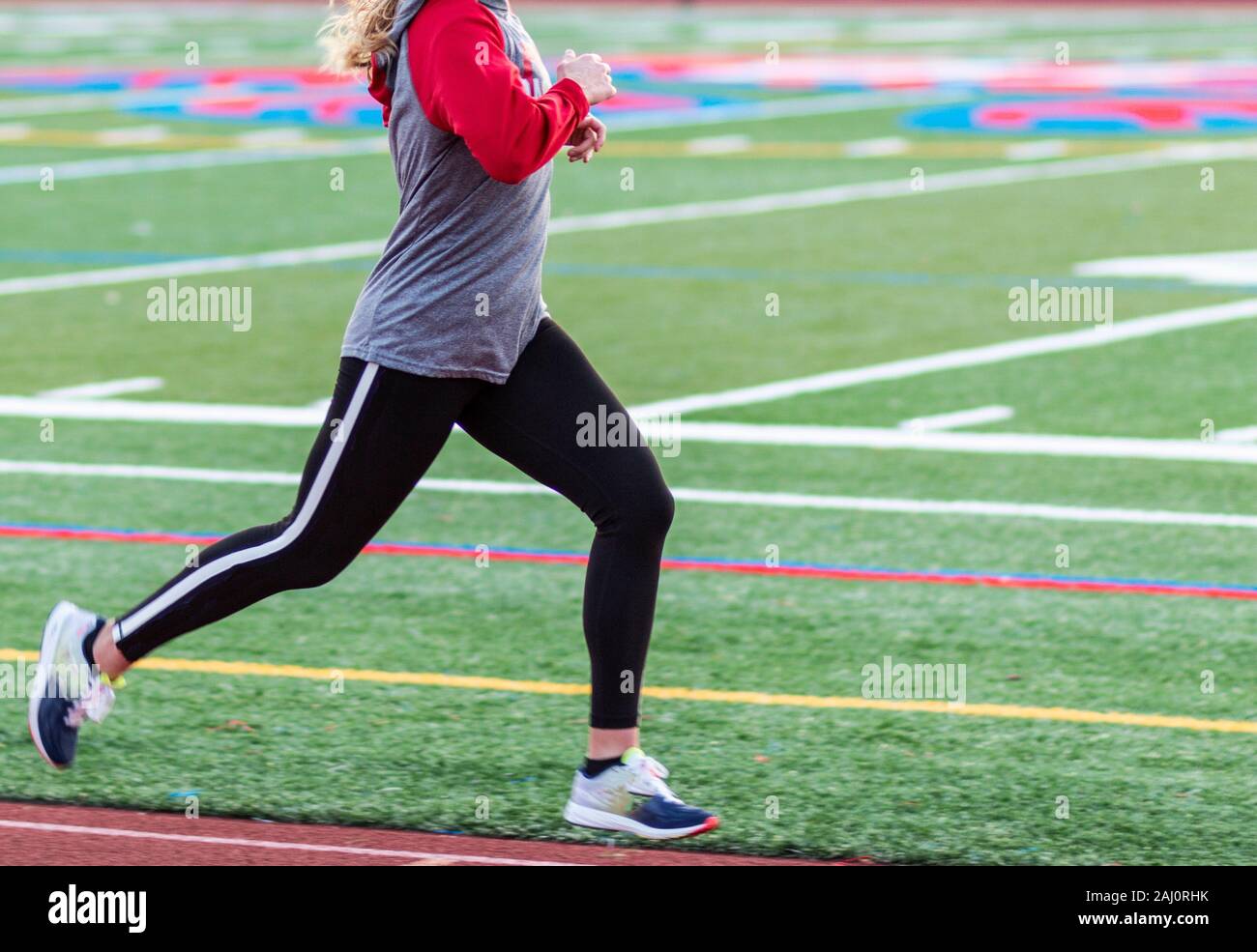 A female distance runner is training by running fast intervals on a ...