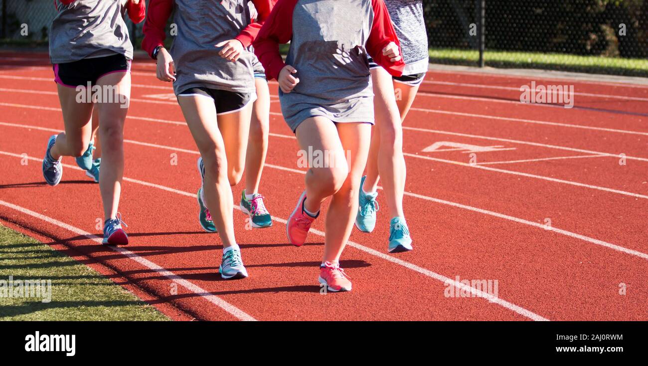 A group of girls train together on a red track running clockwise Stock ...