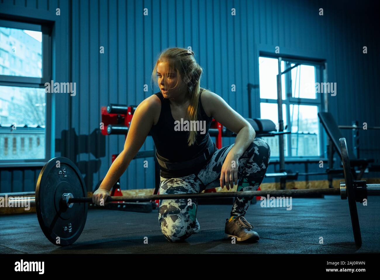 Caucasian teenage girl practicing in weightlifting in gym. Female ...