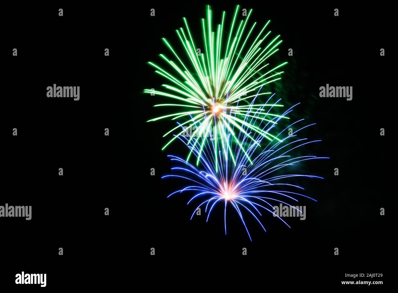 Green and blue colored fireworks explode into a beautiful display for ...
