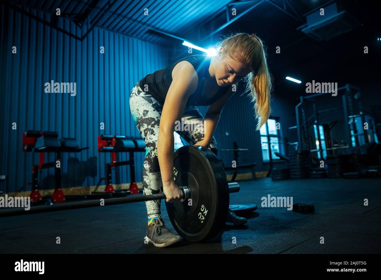 Caucasian teenage girl practicing in weightlifting in gym. Female ...