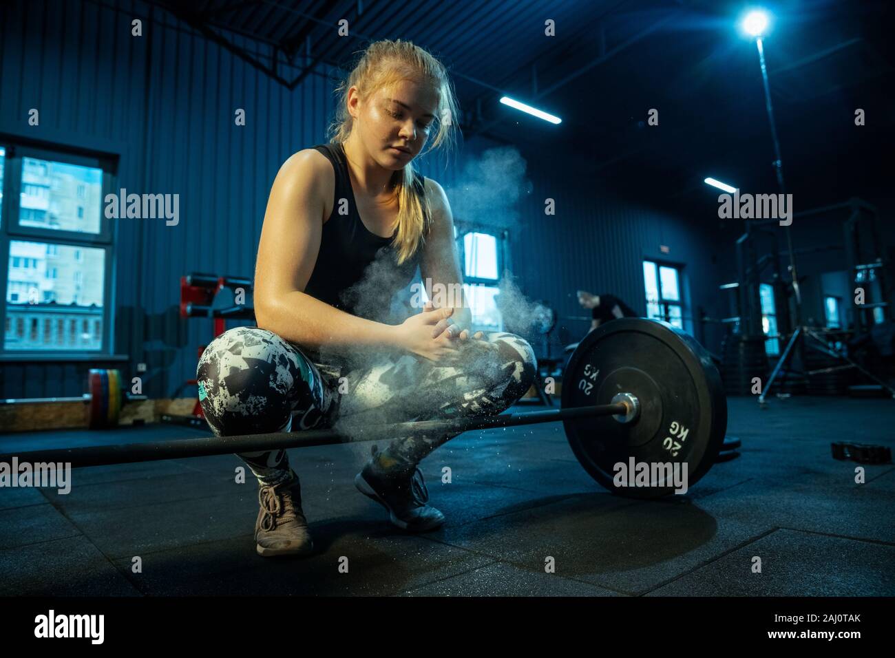 Caucasian teenage girl practicing in weightlifting in gym. Female ...