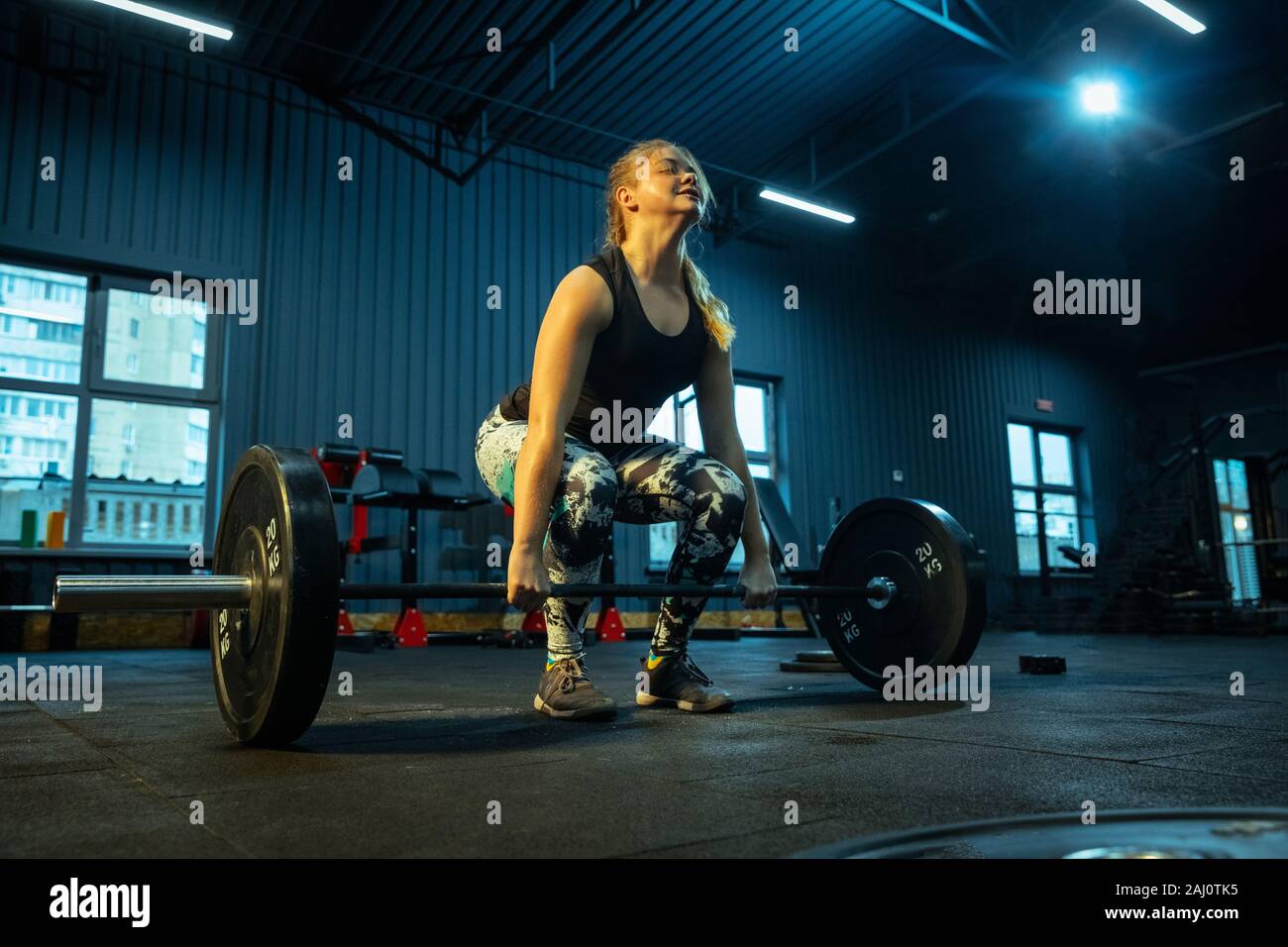 Caucasian teenage girl practicing in weightlifting in gym. Female ...