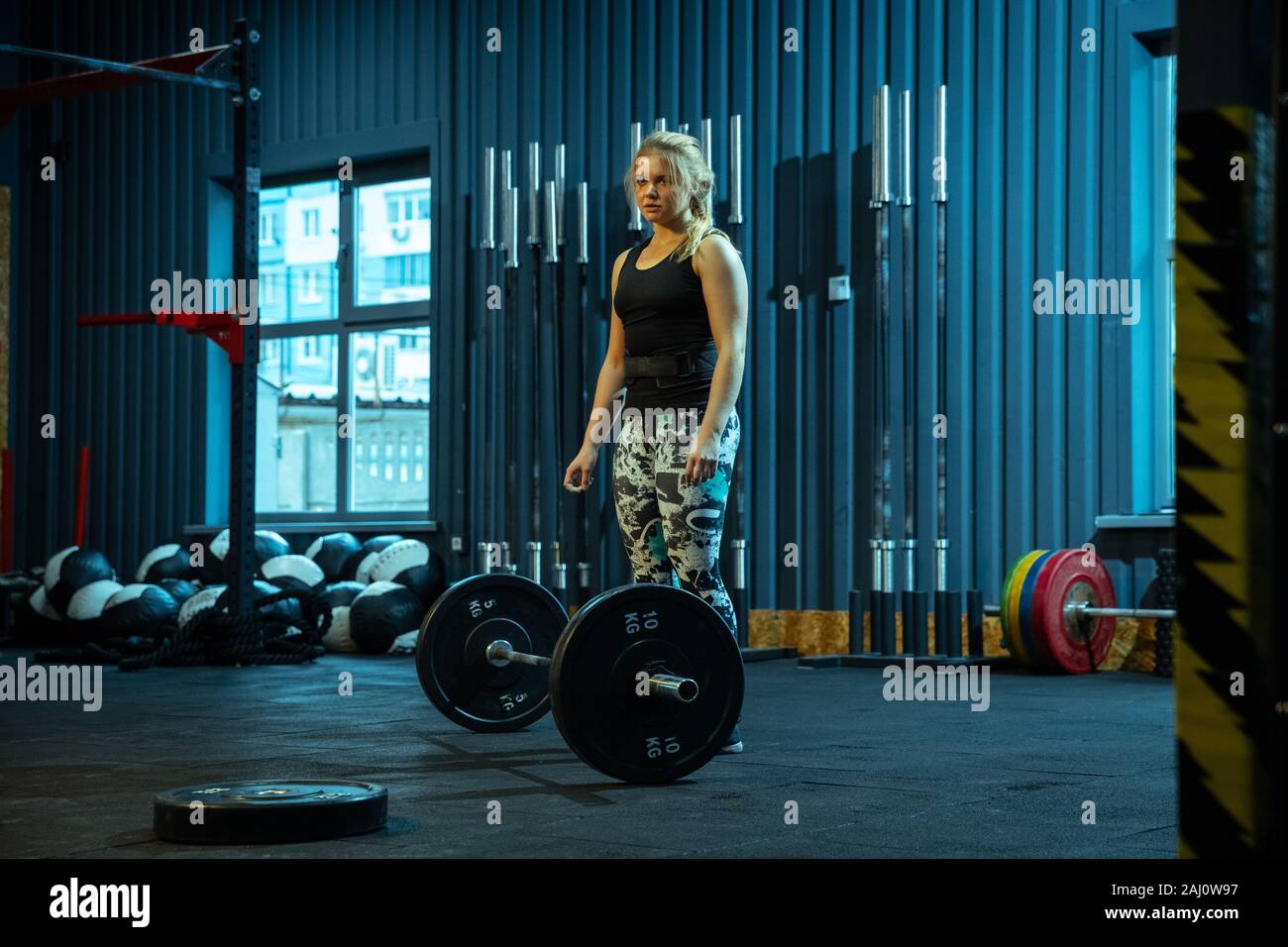 Caucasian teenage girl practicing in weightlifting in gym. Female ...
