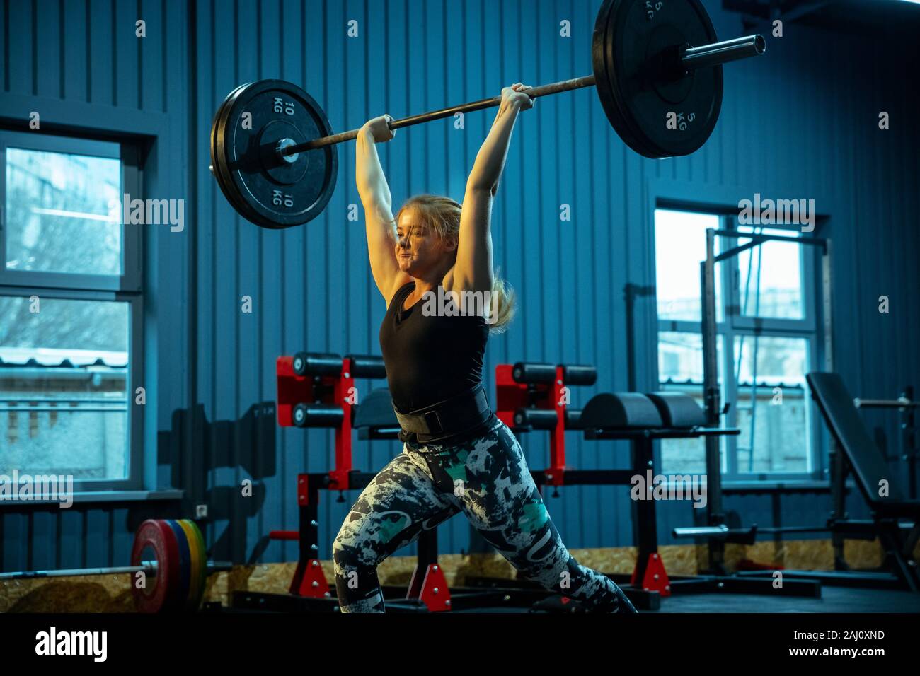 Caucasian teenage girl practicing in weightlifting in gym. Female ...