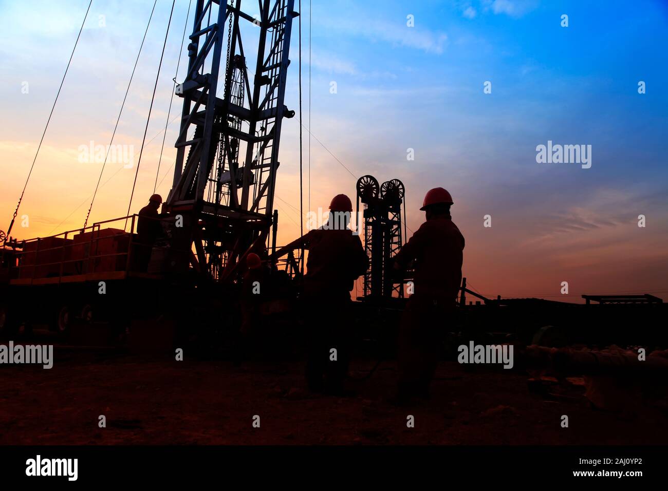 In the evening，oil field, the oil workers are working Stock Photo - Alamy