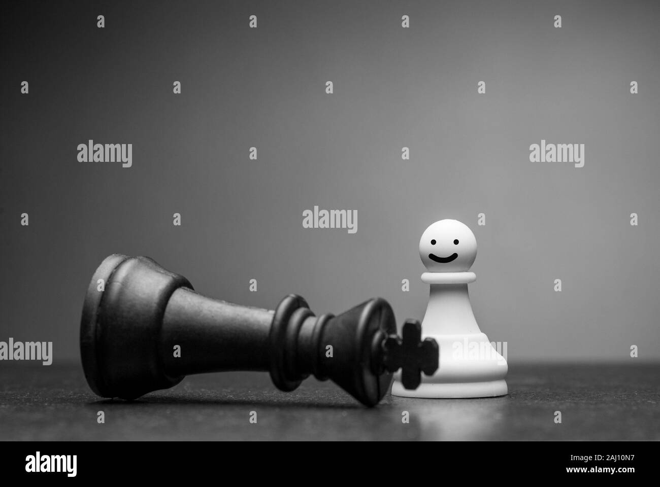 White pawn chess piece smiling at a fallen king Stock Photo - Alamy