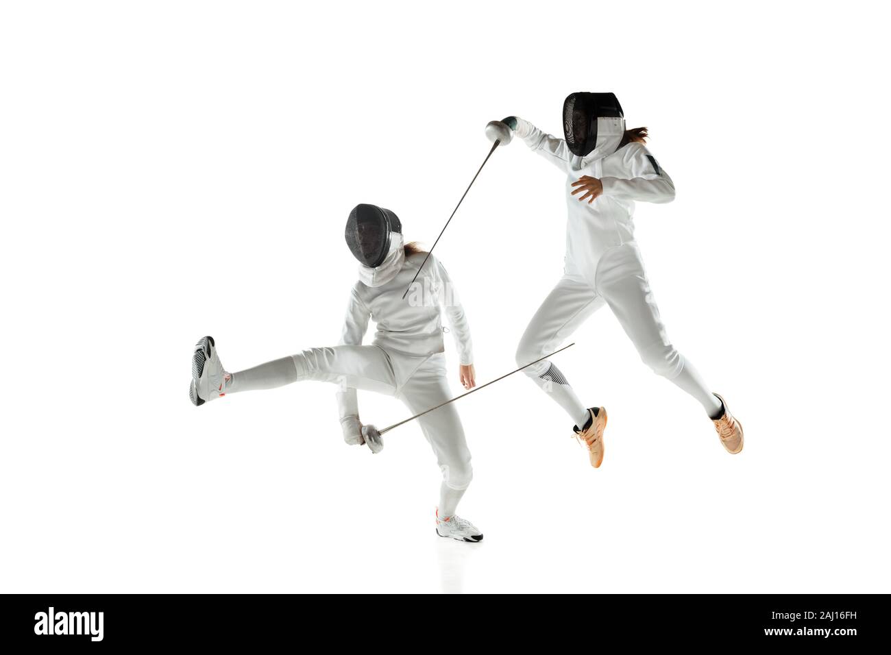 Teen girls in fencing costumes with swords in hands isolated on white ...