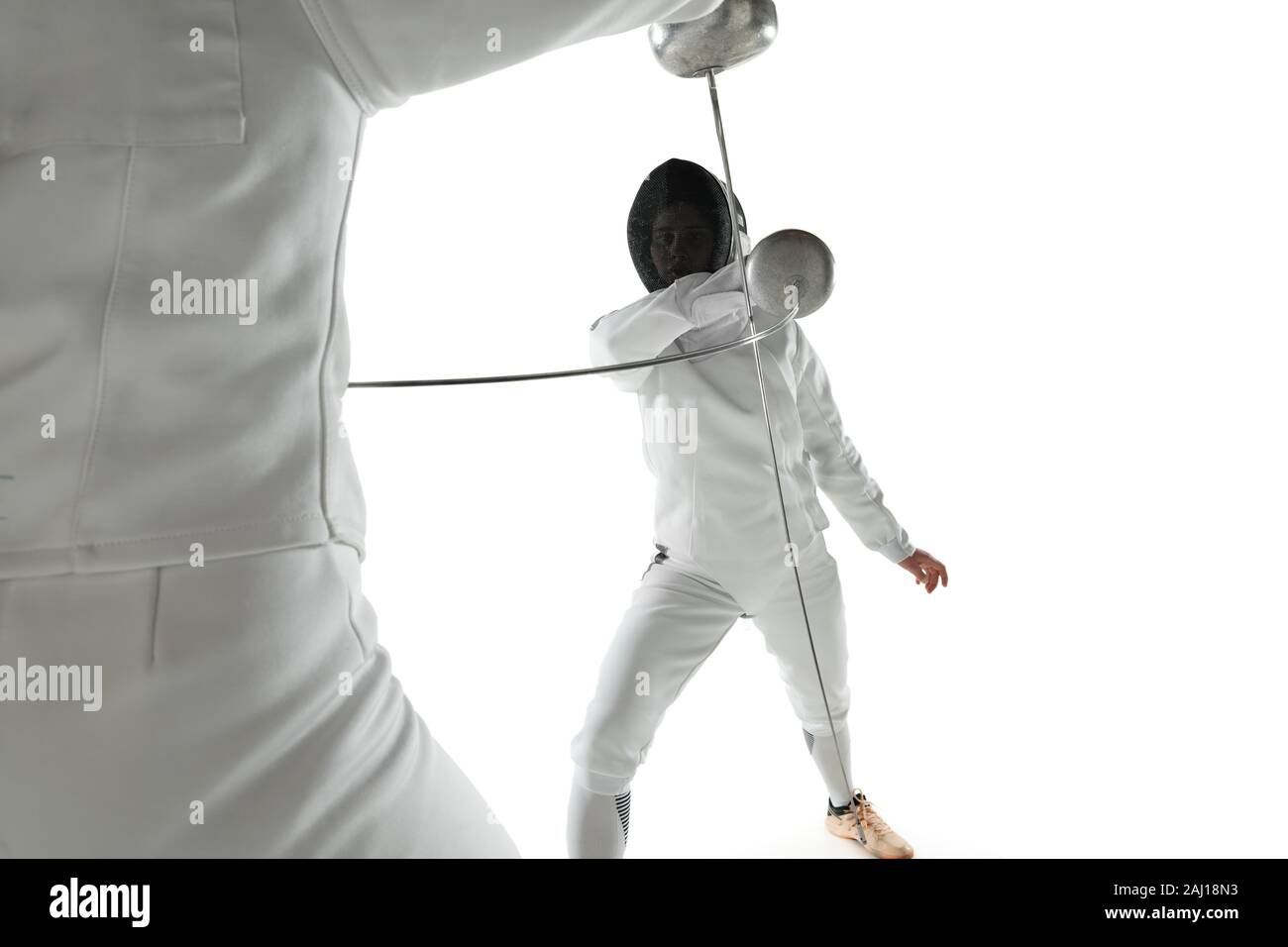Teen girls in fencing costumes with swords in hands isolated on white ...