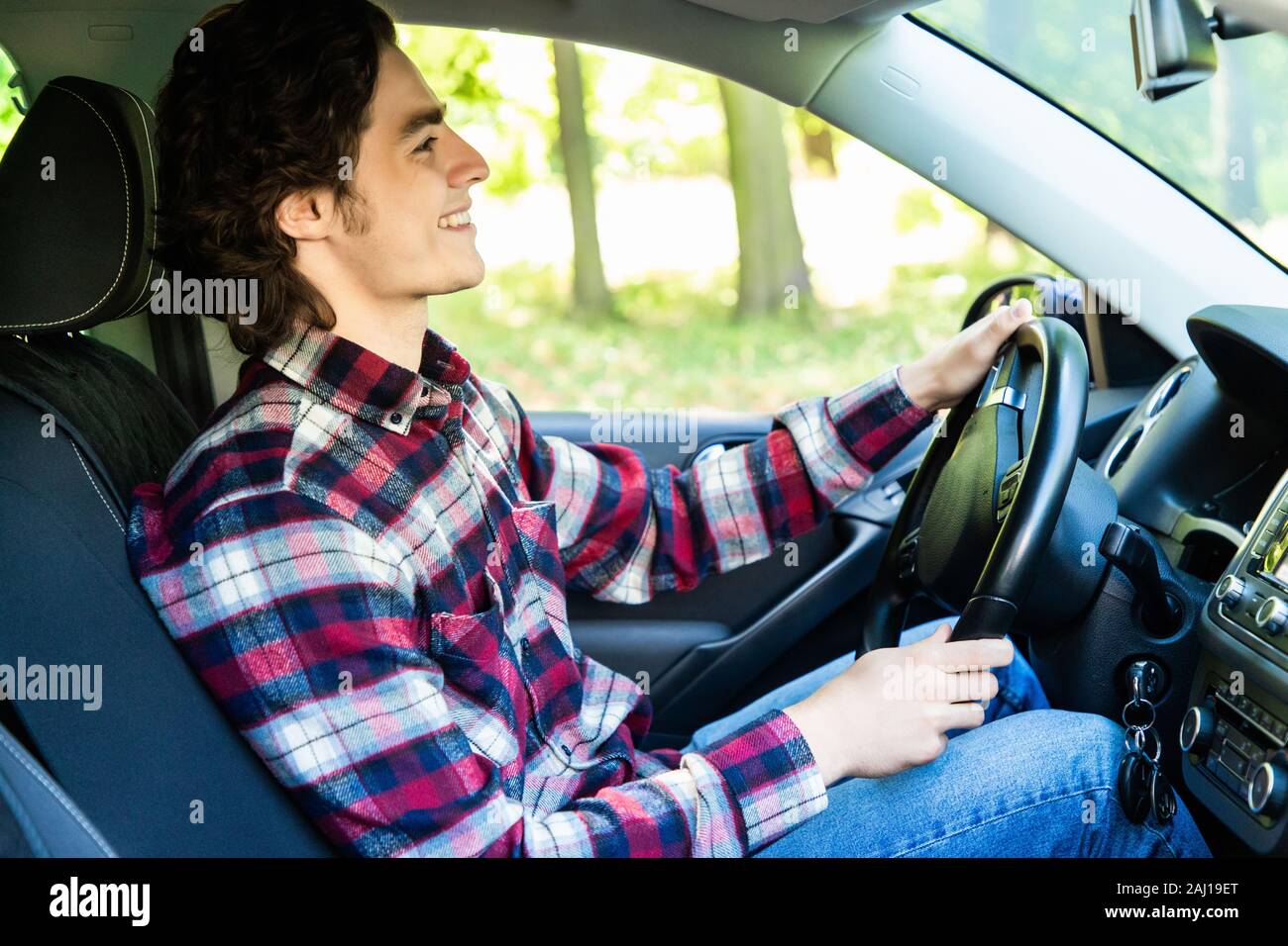 Portrait of a handsome man driving a car and focusing on the road Stock ...