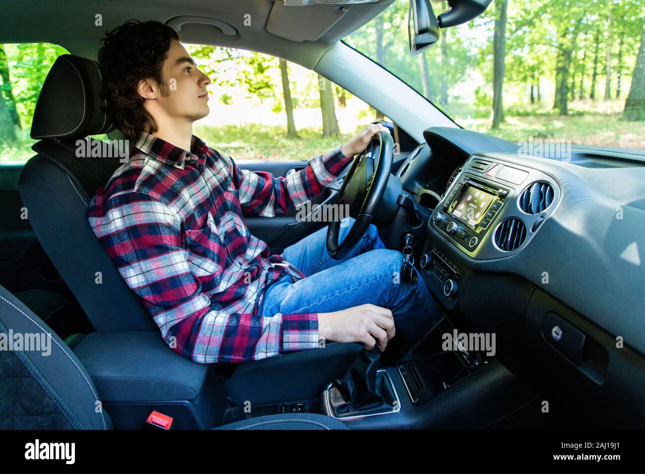 Portrait of a handsome man driving a car and focusing on the road Stock ...