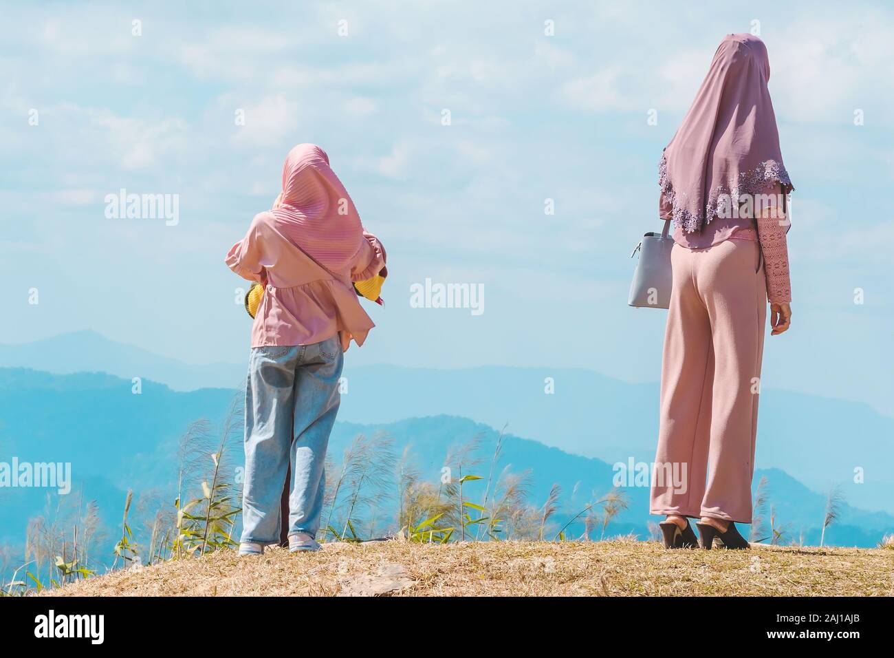 Back view of Muslim women wearing a Muslim dress and hijab enjoy on the ...