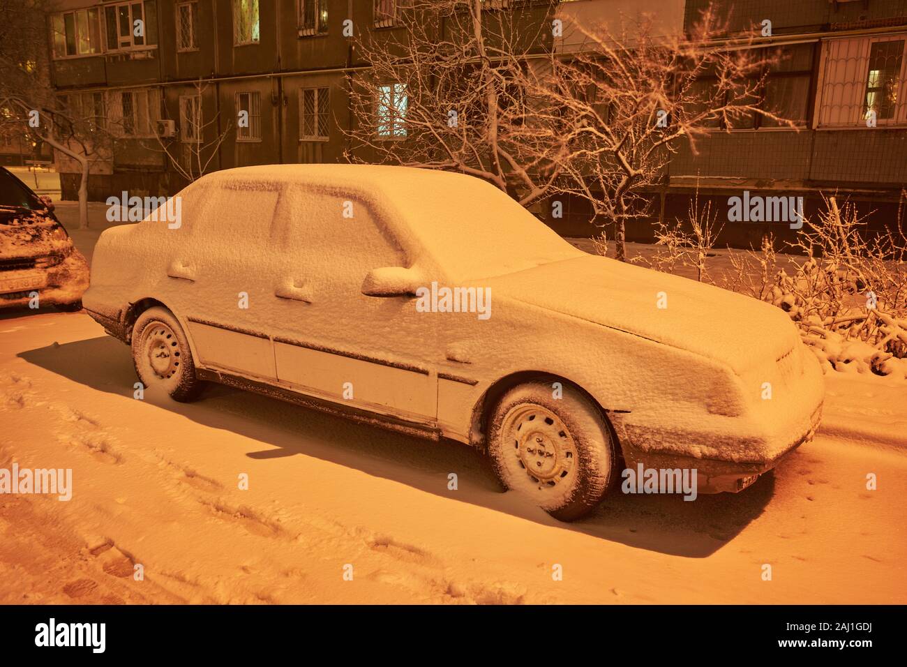 Snow-covered car after snowfall in night city Stock Photo - Alamy