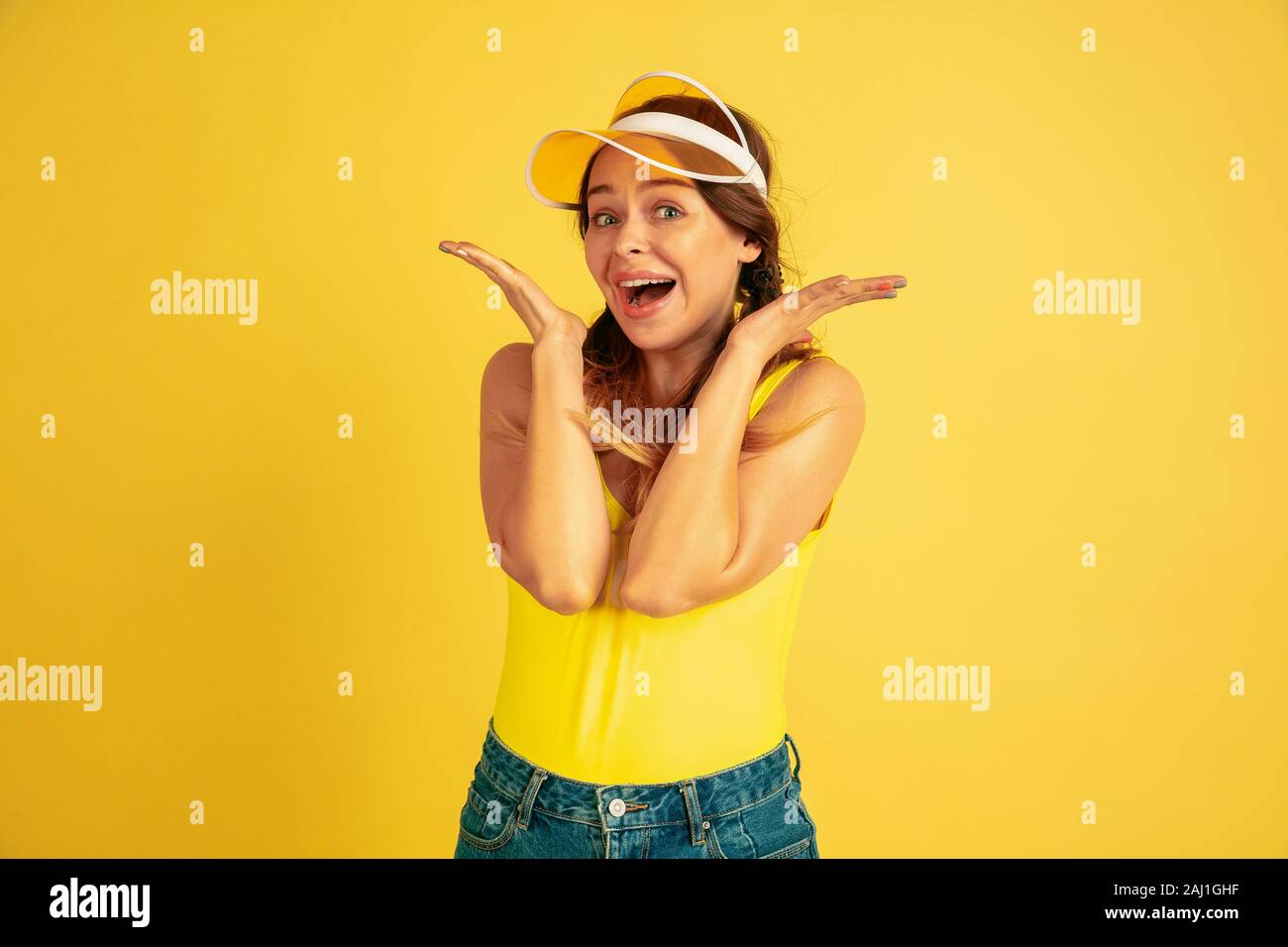 Posing cute, smiling. Caucasian woman's portrait on yellow studio ...