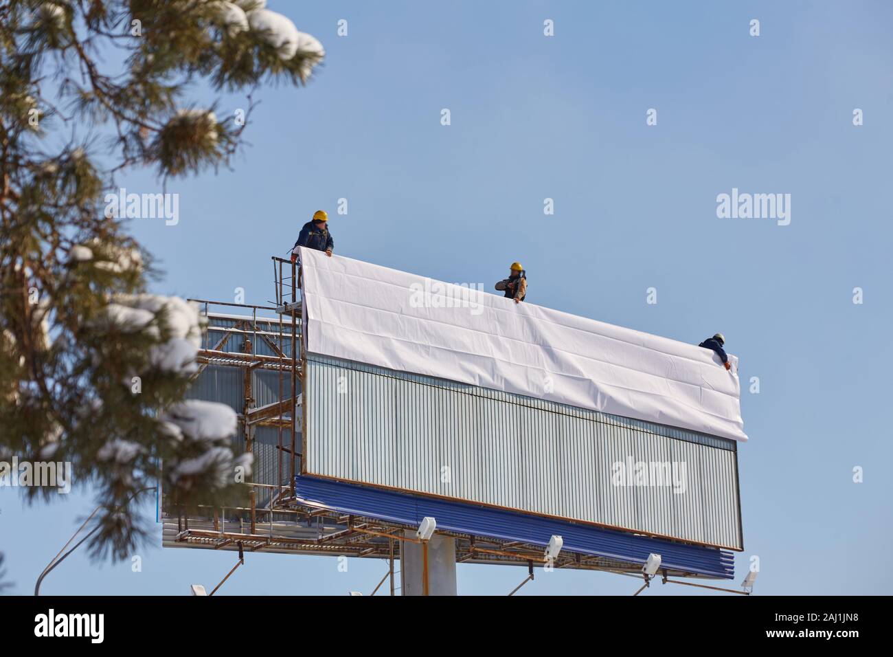 Worker prepares billboard to installing new advertisement. Industrial ...