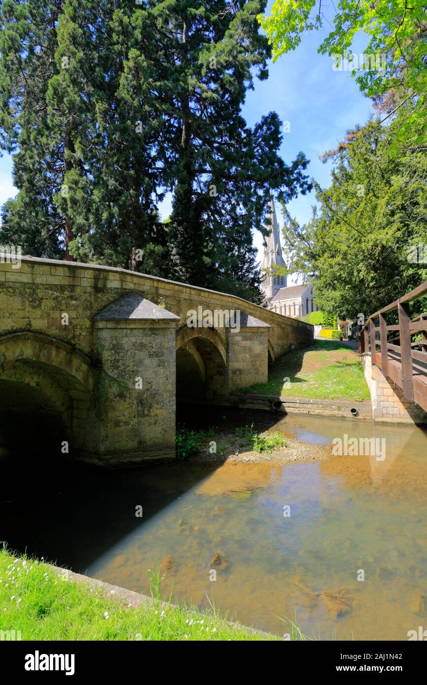 Stone bridge over the river Chater, St Marys church, Ketton village ...