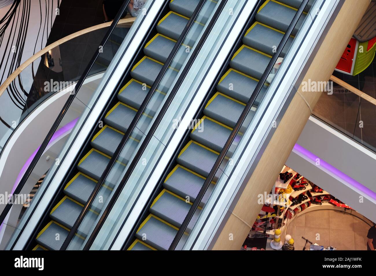 Modern bright shopping mall indoor architecture. Escalator in a shopping center. Interior of ...