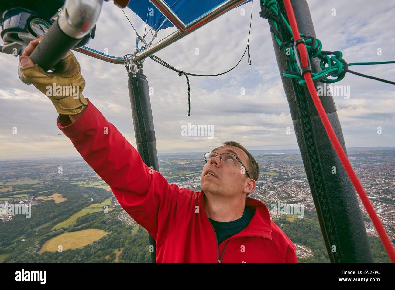 A balloon pilot adjusting the burning gas jets that heat air inside the ...