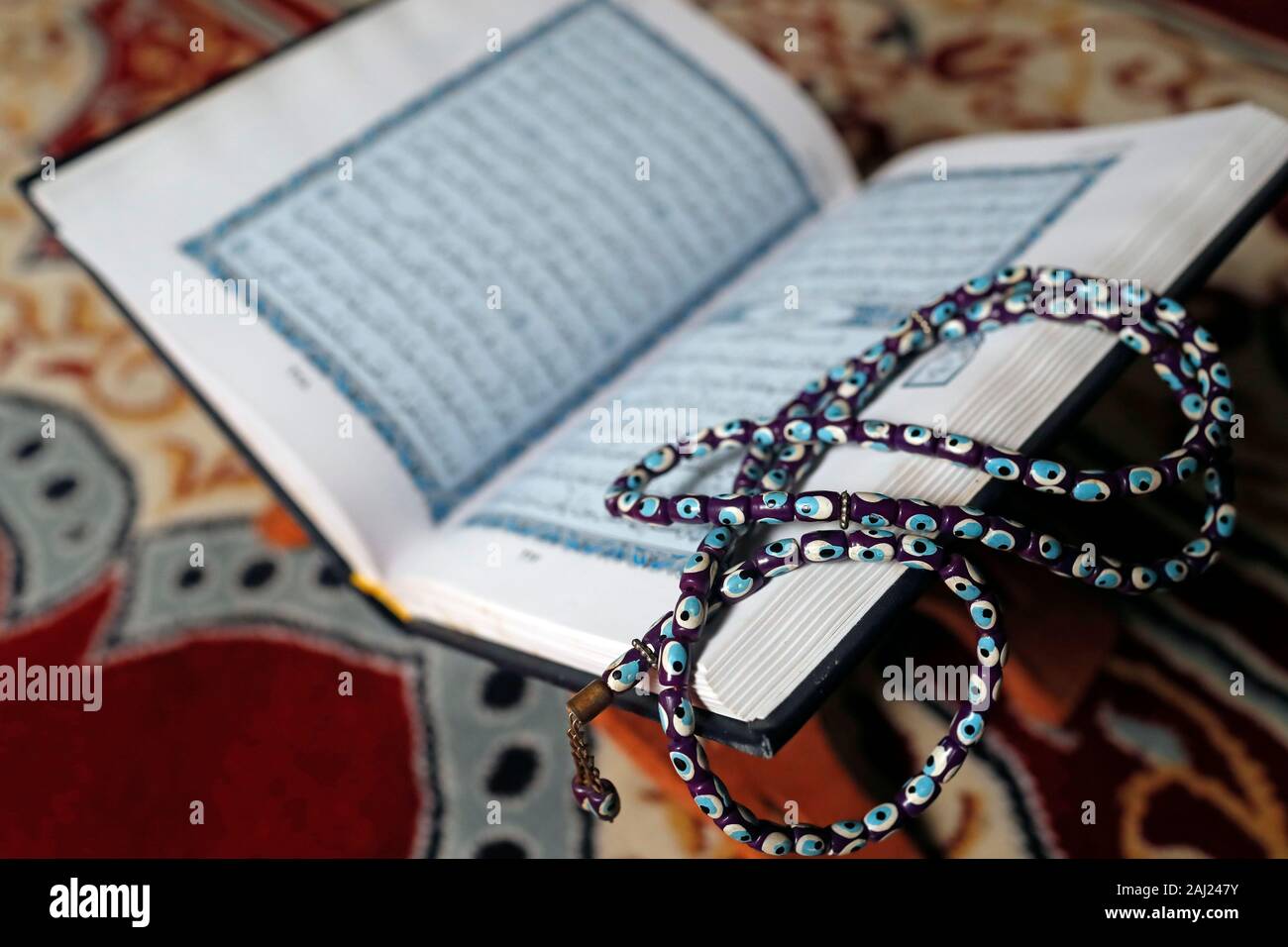 Holy Quran in Arabic and Muslim prayer beads on wood stand, Vietnam ...