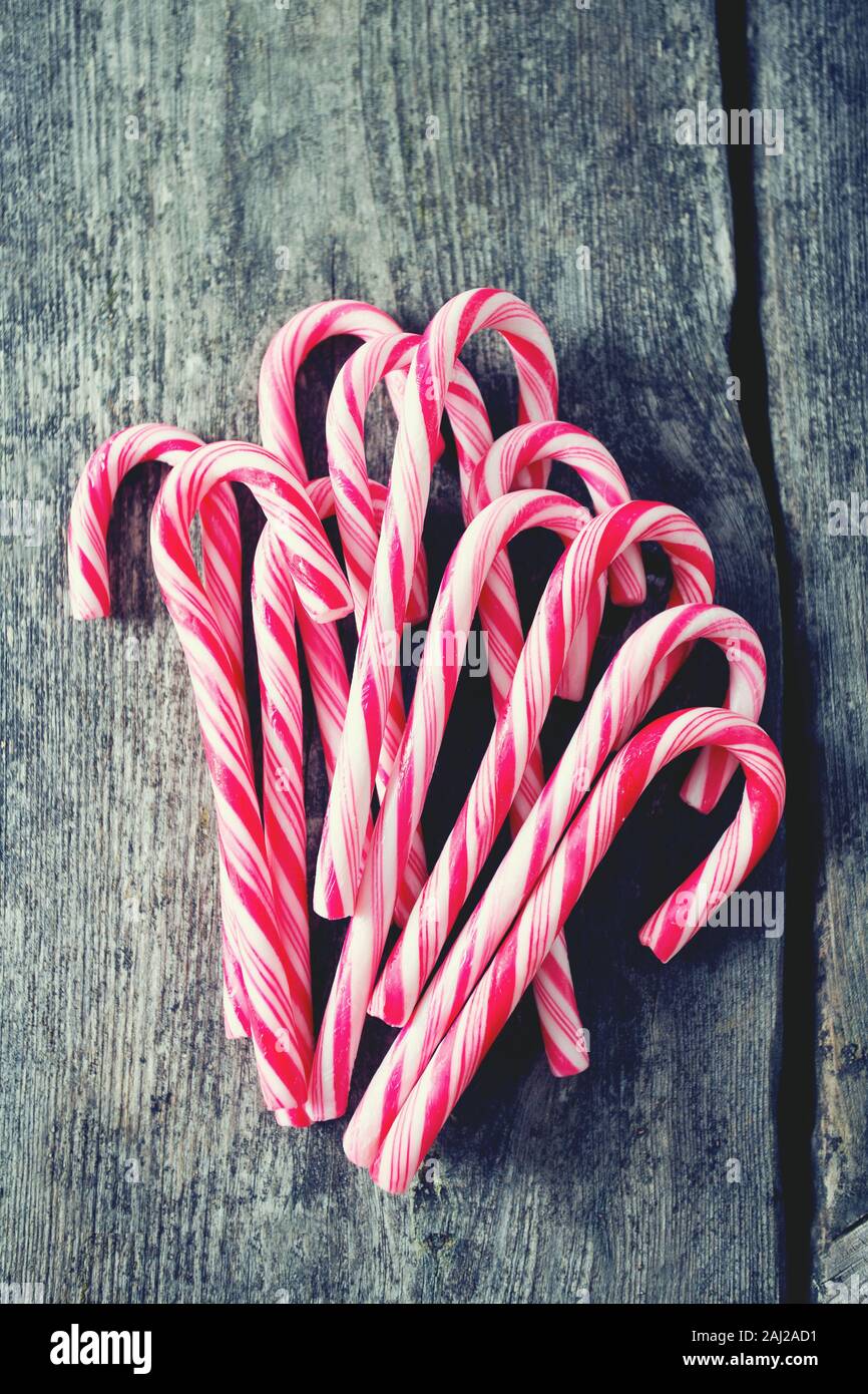 Striped Christmas candies on wooden surface Stock Photo - Alamy