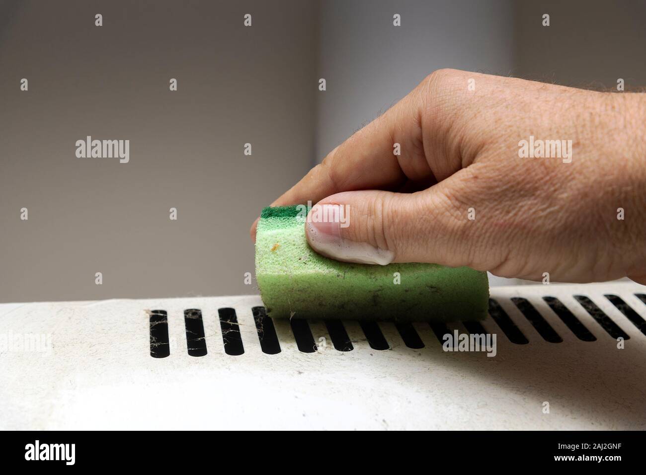 Washing dirty surface in kitchen with green sponge Stock Photo - Alamy