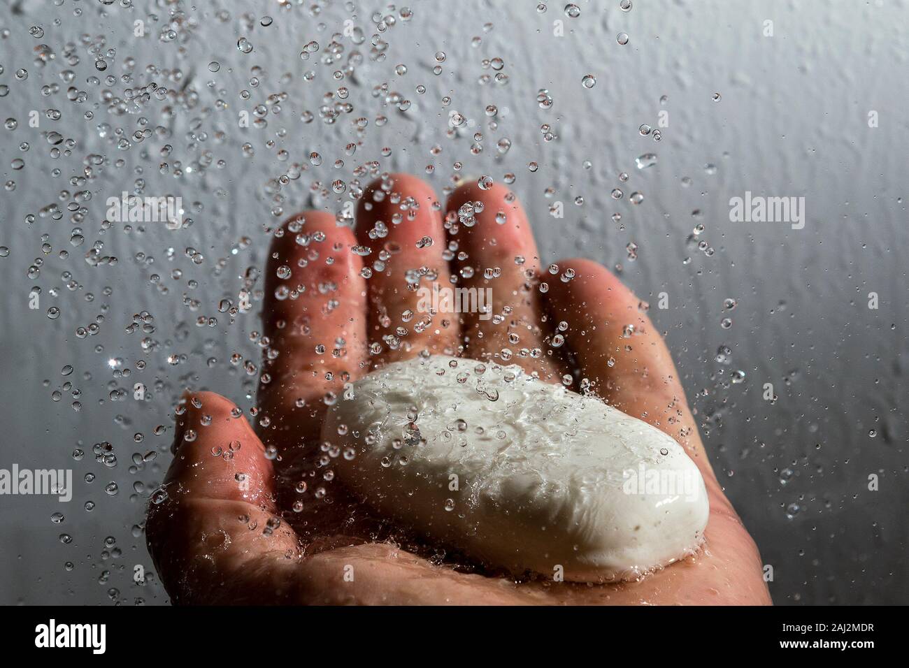 Soap in human hands and falling water Stock Photo - Alamy